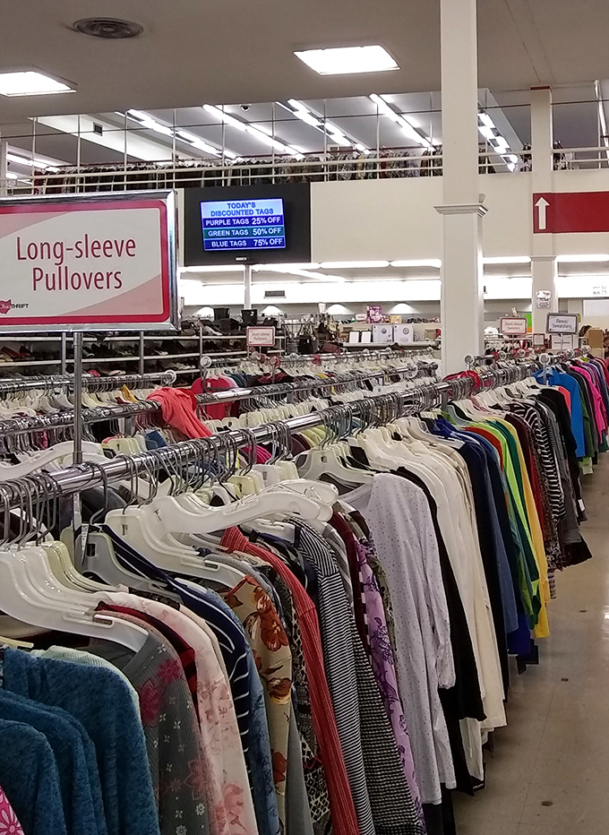 Color-coded clothing racks make treasure hunting efficient. That digital display board announcing today's special discounts is the thrifter's stock market ticker.
