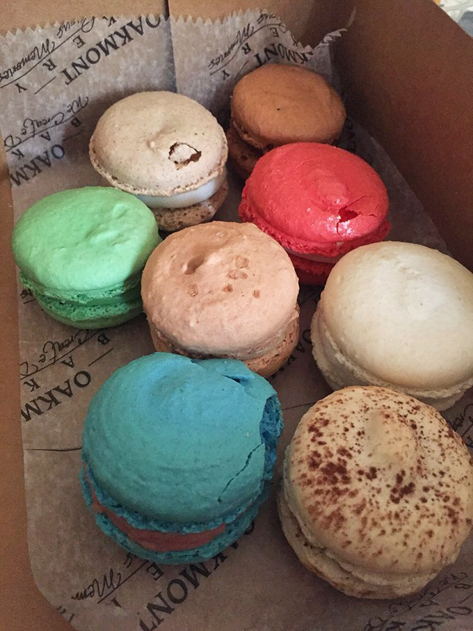 A rainbow of macarons nestled in their box like edible jewels. Each one promises a different journey &ndash; from mint green escapades to raspberry revelations.