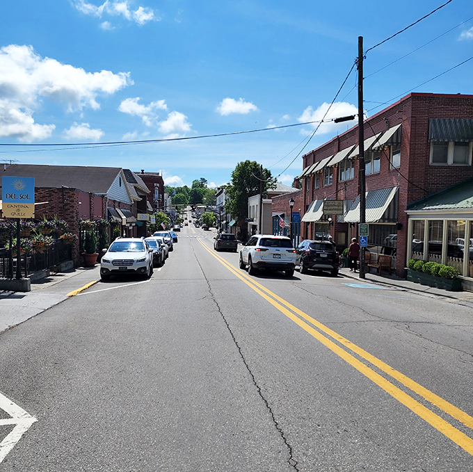 Main Street's gentle curve invites exploration, with locally-owned shops lining both sides like a real-life Monopoly board of possibilities.