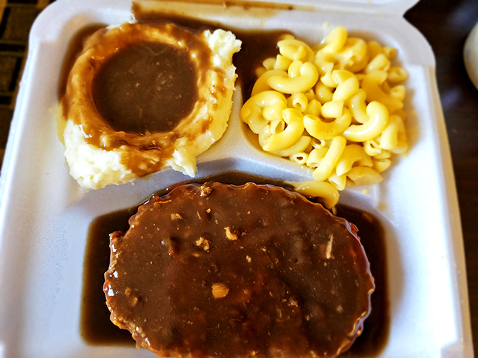 Meatloaf swimming in savory gravy alongside creamy mashed potatoes and mac & cheese – the holy trinity of comfort on a plate.