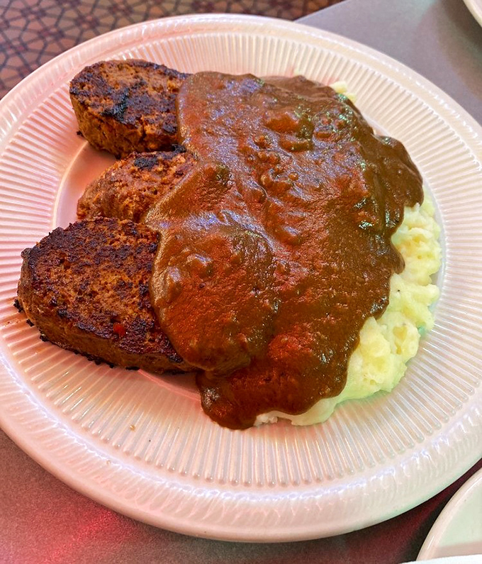 Behold the star attraction: meatloaf that doesn't just sit on the plate&mdash;it commands respect, with gravy cascading over mashed potatoes like a savory waterfall.