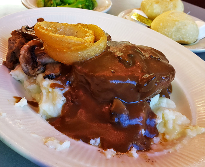Behold the star attraction: meatloaf nestled on cloud-like mashed potatoes, swimming in gravy that would make grandmothers jealous.