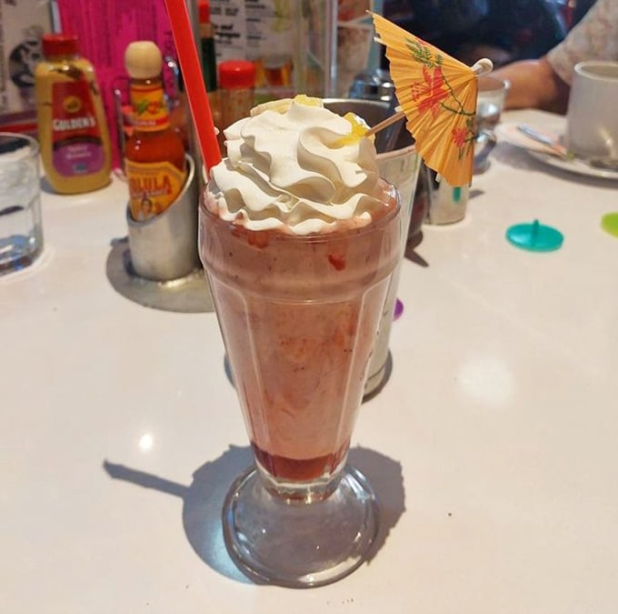 This isn't just a strawberry milkshake; it's summer vacation in a glass, complete with that little paper umbrella that somehow makes everything taste 37% better.