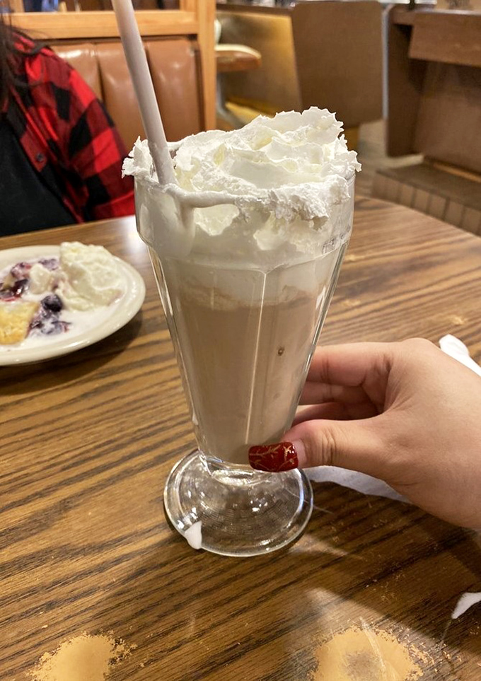 This isn't just a milkshake; it's a towering monument to dairy perfection. That whipped cream crown deserves its own ZIP code.