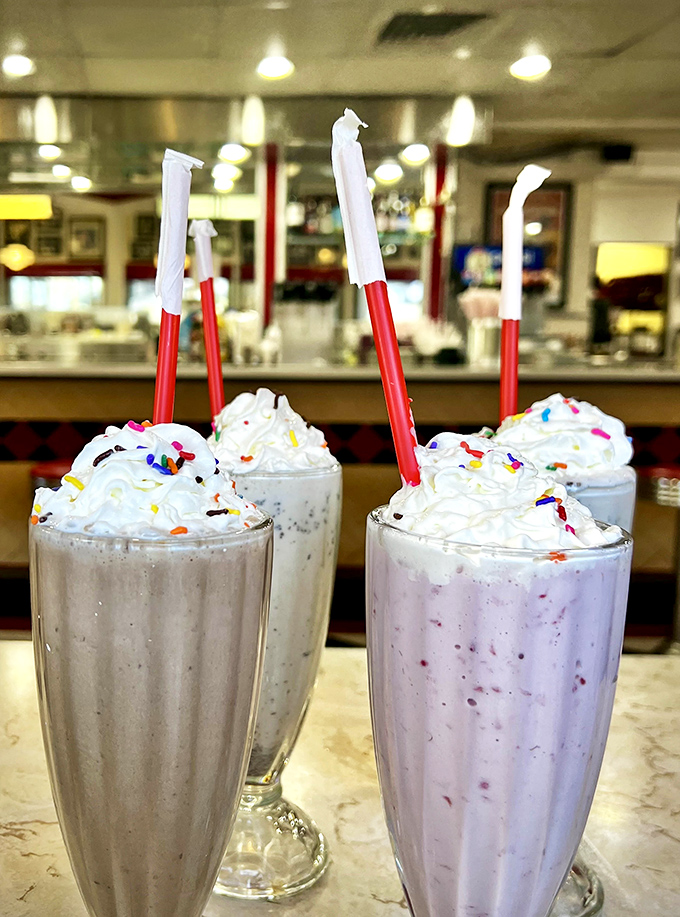 These aren't just milkshakes; they're architectural marvels of dairy engineering, topped with whipped cream mountains and requiring both straw and spoon navigation techniques.