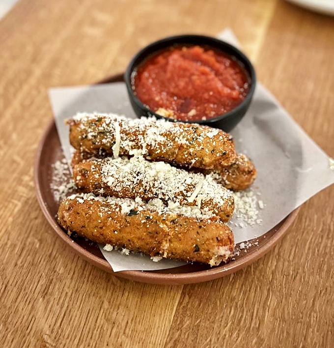 Golden-brown perfection meets gooey cheese dreams in stick form, dusted with herbs and served with marinara that means business.