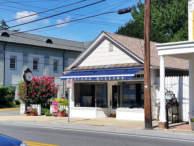 The Oxford Museum stands proudly with its blue awning, collecting memories while that street clock reminds visitors that here, history is always present.