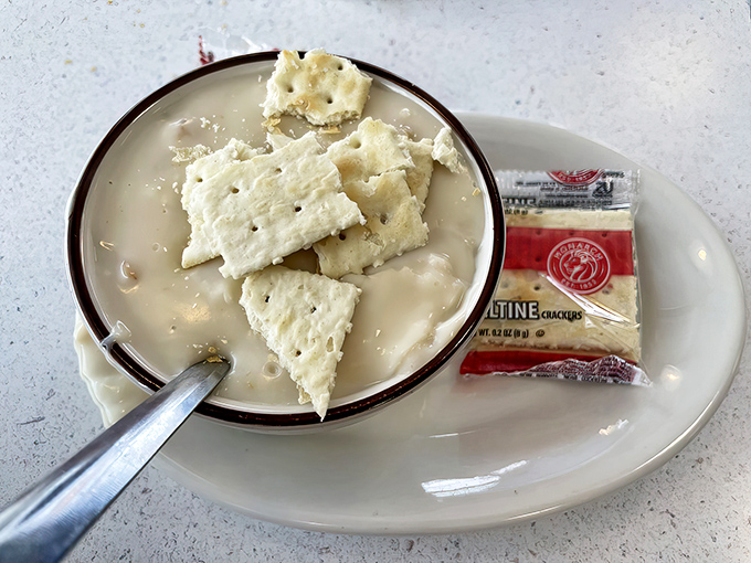 The legendary clam chowder arrives with oyster crackers standing by, ready for their heroic dive into creamy, clam-studded perfection.