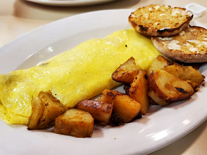 This golden beauty arrives like sunshine on a plate, with home fries that deserve their own zip code. 