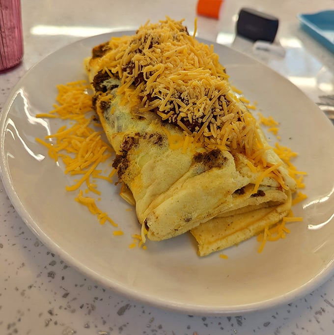 This isn't just an omelet&mdash;it's an architectural achievement. Fluffy egg perfection blanketed with a snowfall of cheese that would make any cardiologist nervously clear their throat.