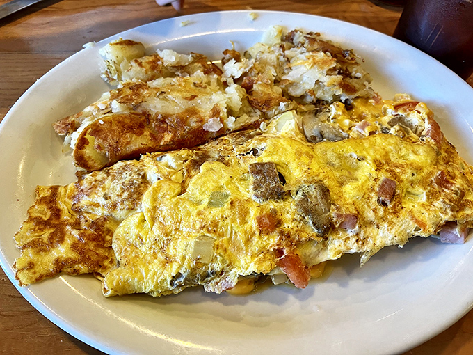 Behold the omelet that launched a thousand road trips. Fluffy eggs embrace a garden of fillings with the kind of generosity that makes sharing optional.