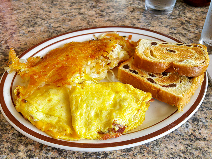 Behold, the star of the show: a perfectly executed omelet with crispy hash browns and cinnamon raisin toast. Breakfast nirvana exists.