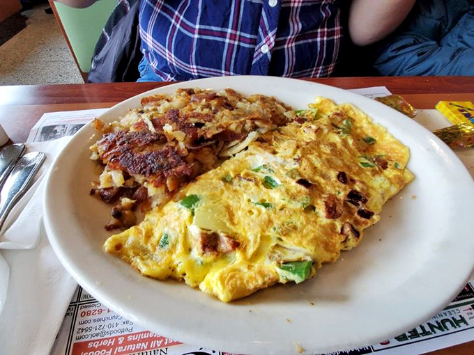 Behold the omelet in its natural habitat &ndash; fluffy, generously filled, and accompanied by home fries that deserve their own fan club.
