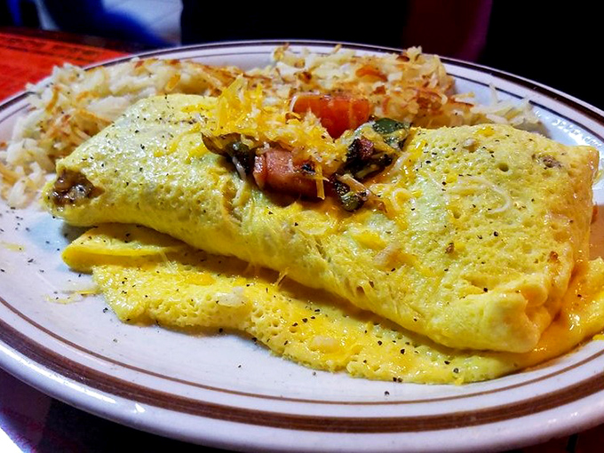 Behold the omelet in its natural habitat&mdash;perfectly folded, generously stuffed, and flanked by a golden mountain of hash browns. Breakfast nirvana achieved.