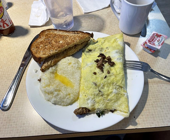 This isn't just an omelet—it's a morning masterpiece with perfectly melted cheese, accompanied by grits that would make any Southerner proud.