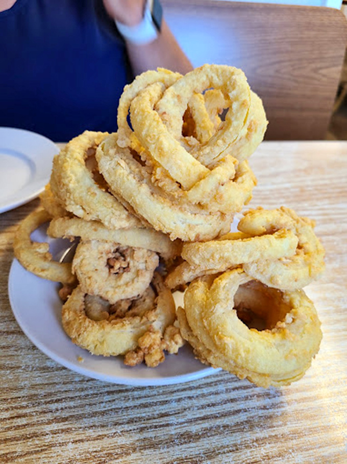 Golden onion rings stacked like delicious Olympic rings. The kind that make that perfect crunch sound that says "diet starts tomorrow."
