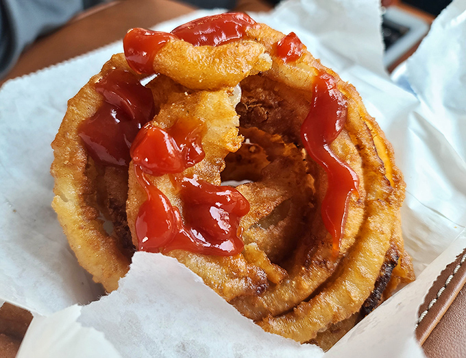 The legendary onion ring in all its glory—a golden halo of crispy perfection with just enough ketchup to make the angels sing.