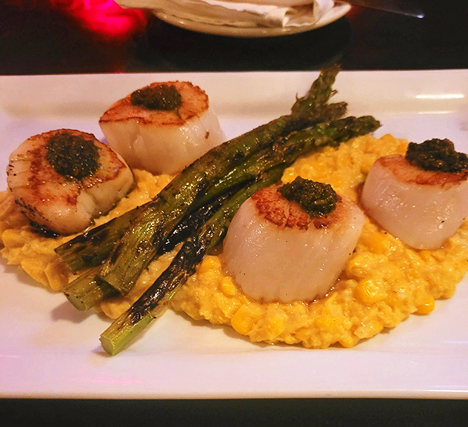 These scallops aren't just seared&mdash;they're transformed into golden-brown flavor coins resting on a bed of sunshine-colored corn that demands your full attention.