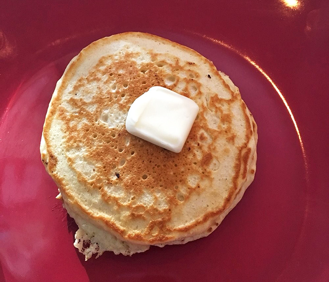 This isn't just a pancake; it's a golden disc of breakfast perfection with a pat of butter slowly creating a pool of melty goodness.