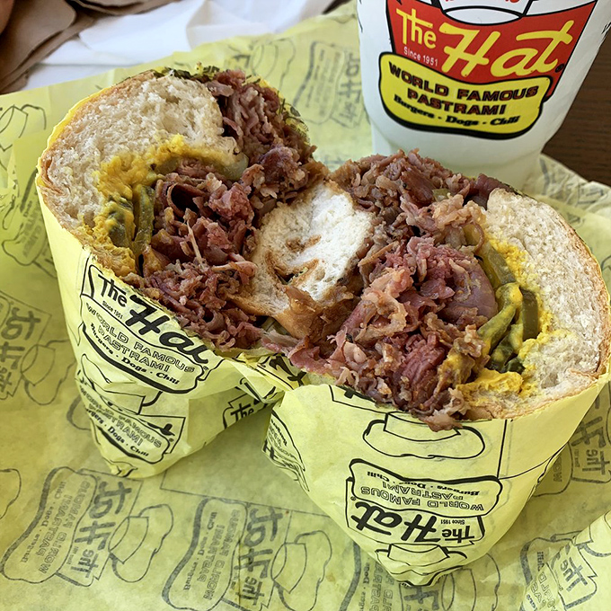 Behold the star of the show: layers of thinly-sliced pastrami piled higher than your weekend to-do list. This isn't a sandwich; it's an event.