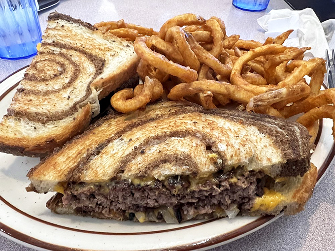 This patty melt isn't just a sandwich; it's a masterclass in the art of comfort food, complete with perfectly crispy onion rings.