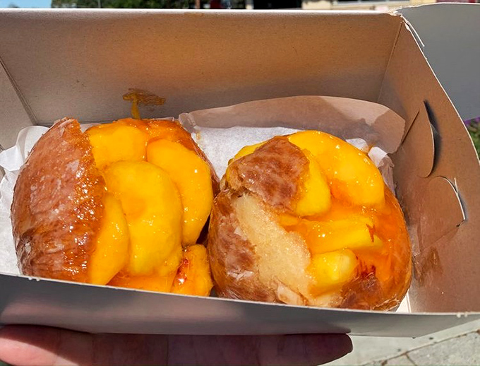 Summer's golden treasure: fresh peaches nestled in pillowy donut perfection. Like catching sunshine in your hands, only sweeter and significantly more worth the sticky fingers.
