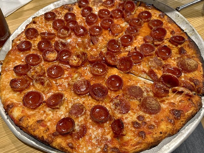 Behold the crown jewel: perfectly cupped pepperoni creating tiny flavor pools on a thin, crispy crust that defies the laws of pizza physics.