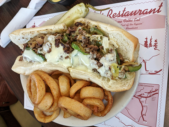 Behold the star attraction &ndash; Clyde's legendary Philly cheesesteak with perfectly caramelized onions and peppers, served with crispy onion rings that deserve their own fan club.