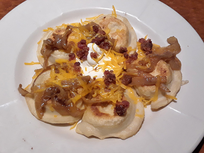Pillowy pierogies crowned with caramelized onions, crispy bacon bits, and melted cheese&mdash;proof that heaven exists and it's made of potato dough.