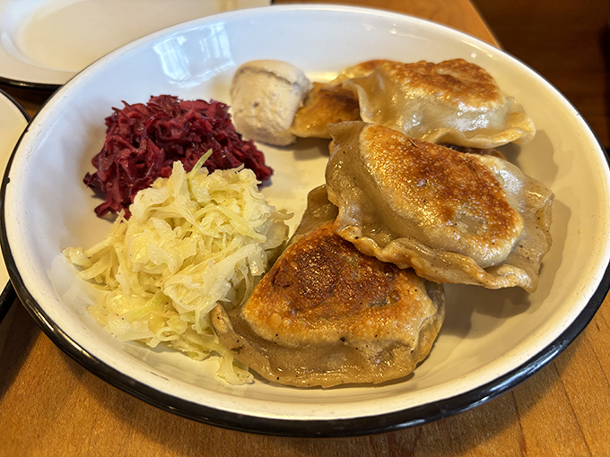 Golden-brown pierogies that could make a carnivore forget meat exists, served with traditional sauerkraut and vibrant beet salad. Dumpling nirvana achieved!
