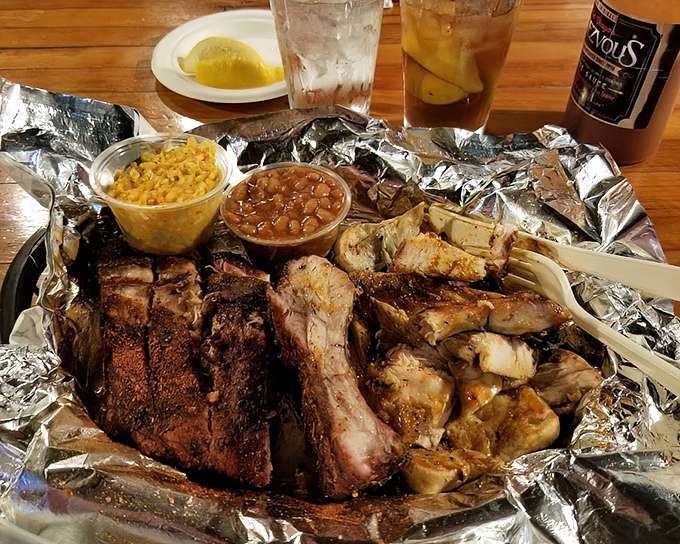 The holy trinity of Memphis dining: dry-rubbed ribs, chicken, and sides nestled in their foil throne. Napkins required, restraint optional.