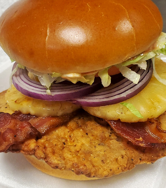 Behold the legendary tenderloin, escaping its bun boundaries like a crispy golden UFO landed on your plate.