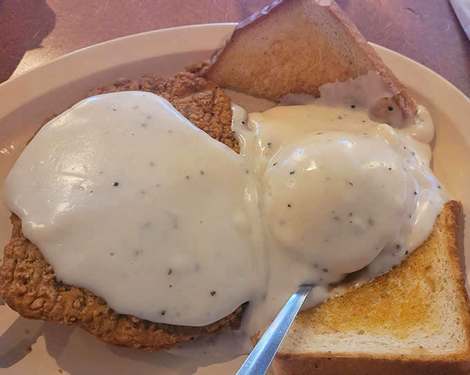 Country fried steak smothered in pepper gravy that could make a vegetarian question their life choices. This is comfort food with a PhD in satisfaction.