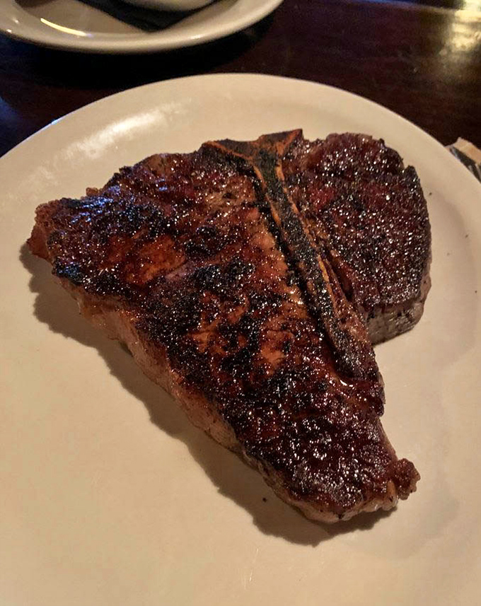 The Porterhouse arrives like a meaty monument to excellence. That perfect char gives way to a tender interior that makes you question every other steak you've ever loved. 