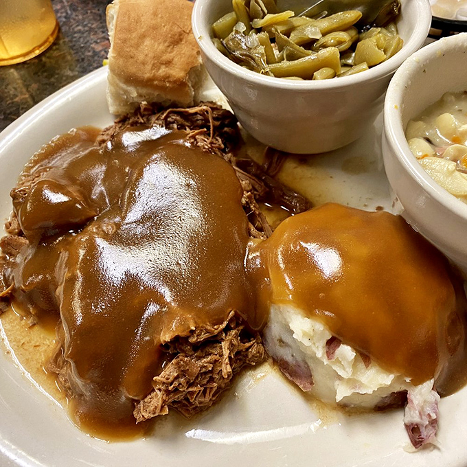 Behold the pot roast in all its gravy-drenched glory! Tender meat surrendering to your fork, with sides that aren't afterthoughts but worthy companions.