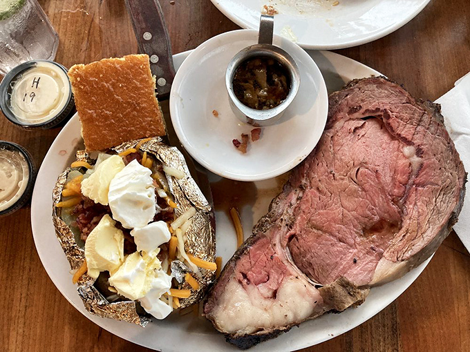 Prime rib so perfectly pink it should come with its own runway. That loaded baked potato sidekick isn't just playing a supporting role.