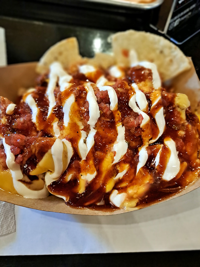 These loaded nachos aren't just a starter—they're an edible Jackson Pollock masterpiece. That zigzag of sauce is the signature of a chef who understands joy.