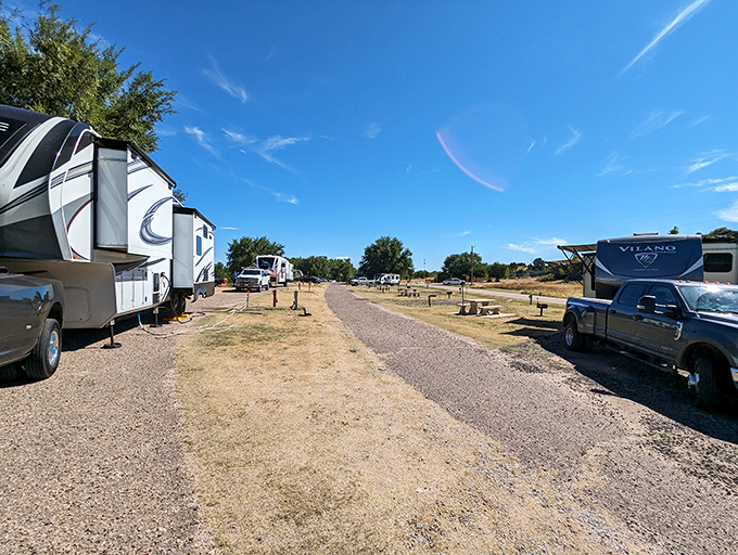 The RV campground stretches under endless blue skies, offering front-row seats to the greatest show on earth.