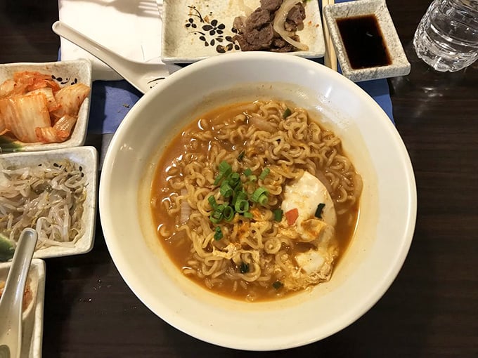 This isn't your college dorm ramen &ndash; it's a soul-warming bowl where curly noodles swim in broth that's been simmering longer than most TV shows run.