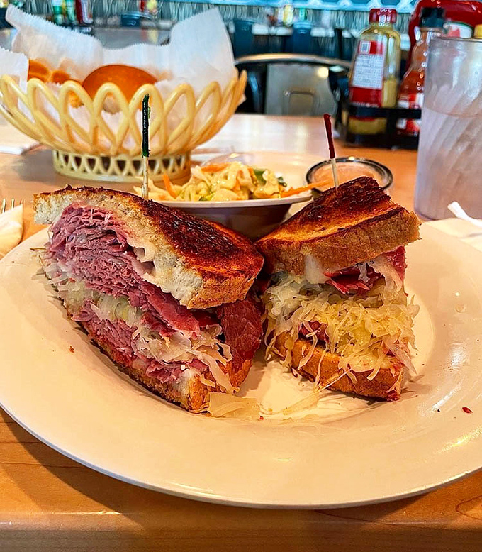 Behold the star of the show! This Reuben isn't just a sandwich; it's an architectural marvel of corned beef, sauerkraut, and melty Swiss.
