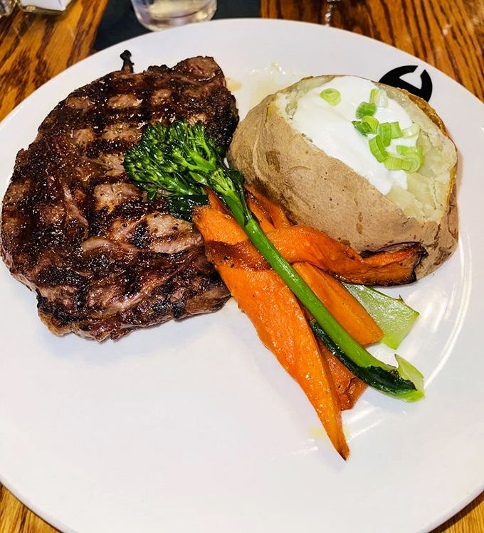 A perfectly charred ribeye with that textbook crosshatch pattern, loaded baked potato, and vibrant vegetables. This isn't dinner &ndash; it's edible artwork.