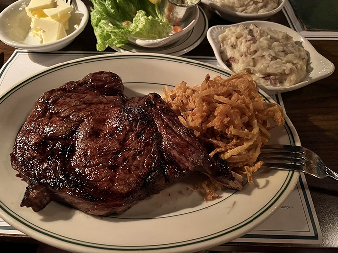 Behold the star of the show: a perfectly charred ribeye with that glistening crust that whispers, "Your diet starts tomorrow."
