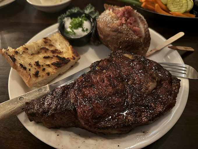 The star of the show: a perfectly charred ribeye with a baked potato sidekick. Meat candy that makes vegetarians question their life choices.
