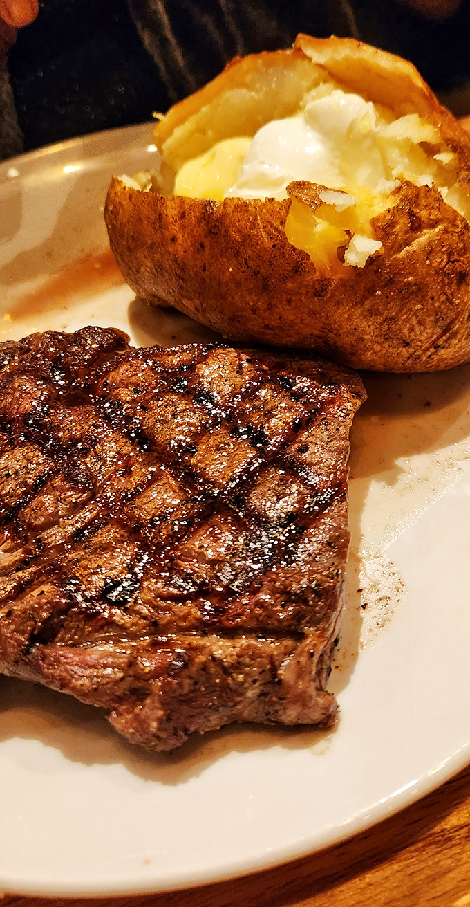 Behold the perfect marriage: a gloriously charred ribeye alongside a baked potato that's practically bursting with buttery anticipation.