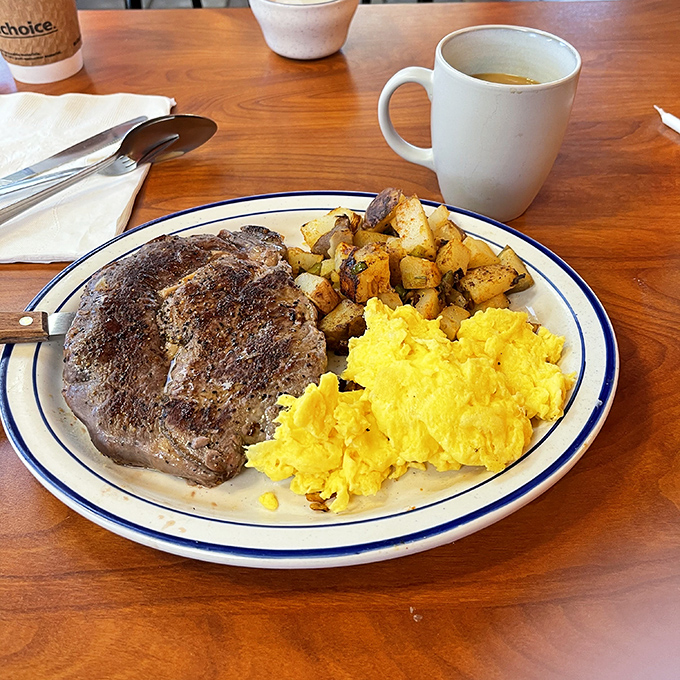 A perfect trifecta: juicy ham steak, sunshine-yellow eggs, and potatoes crisped to golden perfection. The holy trinity of diner breakfasts done right.
