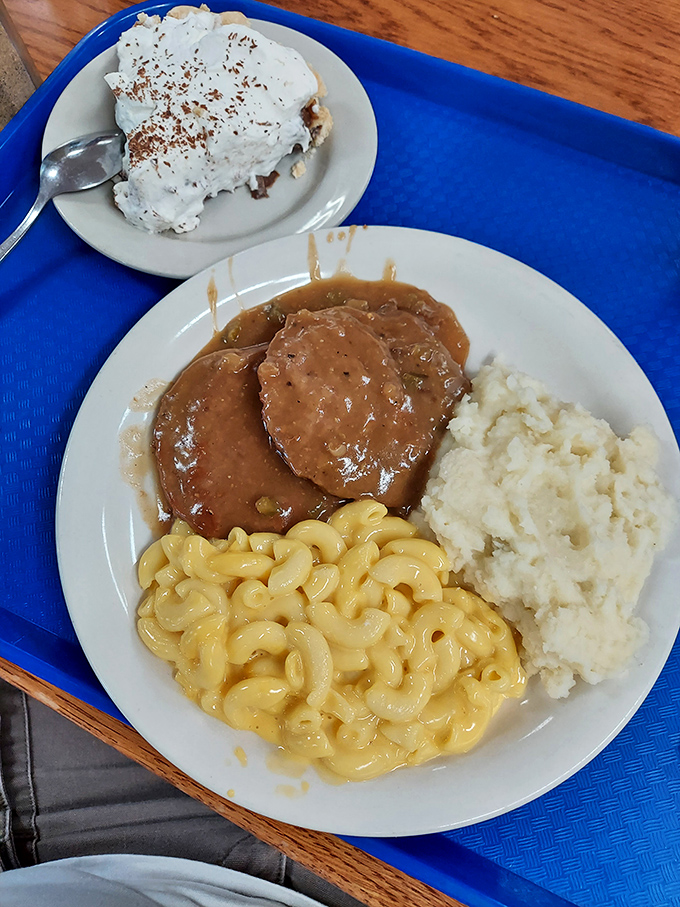 Salisbury steak swimming in gravy alongside mac and cheese that's creamier than a jazz saxophone solo on a Sunday afternoon.