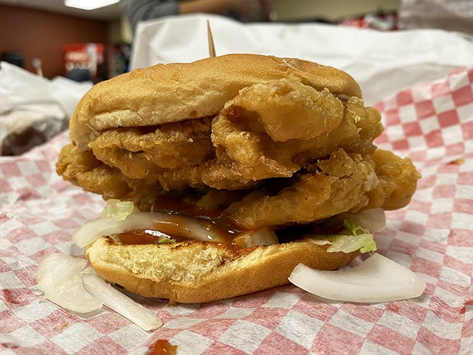 Behold the star of the show! This pork tenderloin sandwich defies the laws of bun physics with golden-fried goodness spilling gloriously over the edges. 