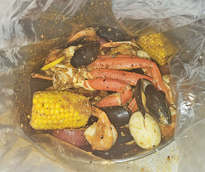Behold the main event: a glorious seafood boil where crab legs, corn, potatoes, and shellfish commingle in spiced harmony.