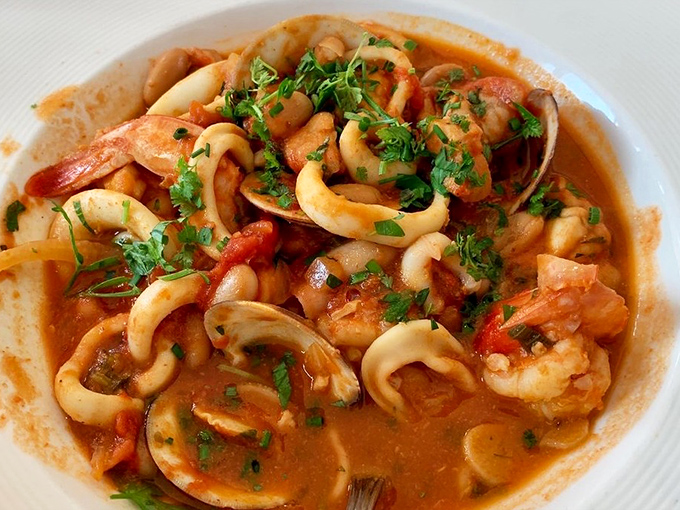 The Seafood Zarzuela arrives like a Spanish love letter to the ocean&mdash;shrimp, clams, and calamari swimming in a tomato broth that demands to be sopped up.