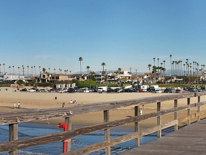 The Seal Beach Pier stretches toward the horizon like a wooden runway, inviting visitors to stroll above the gentle Pacific swells.